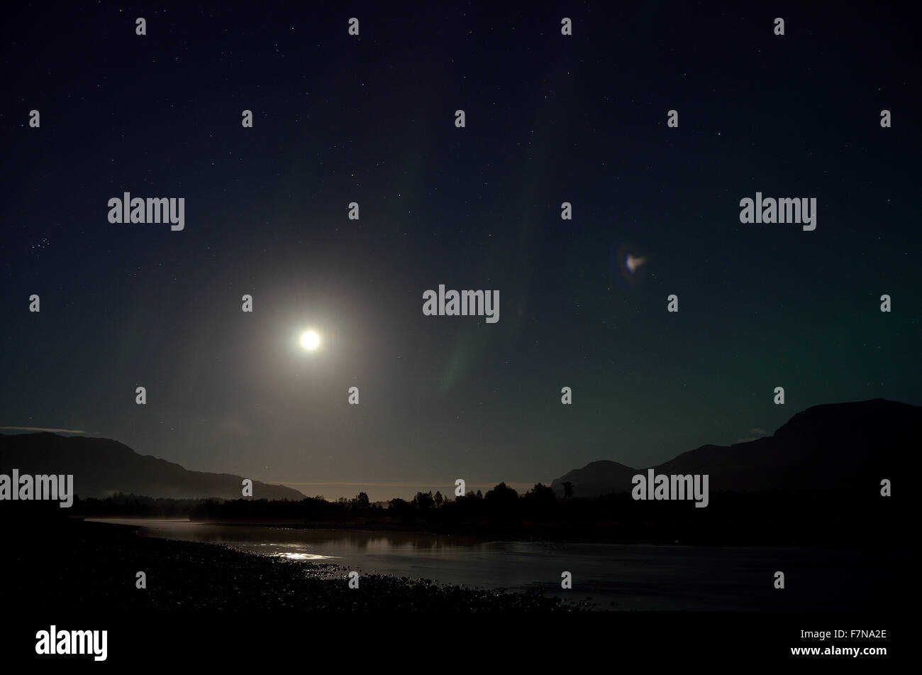 faded aurora borealis on full moon night as the moonlight reflected by ...