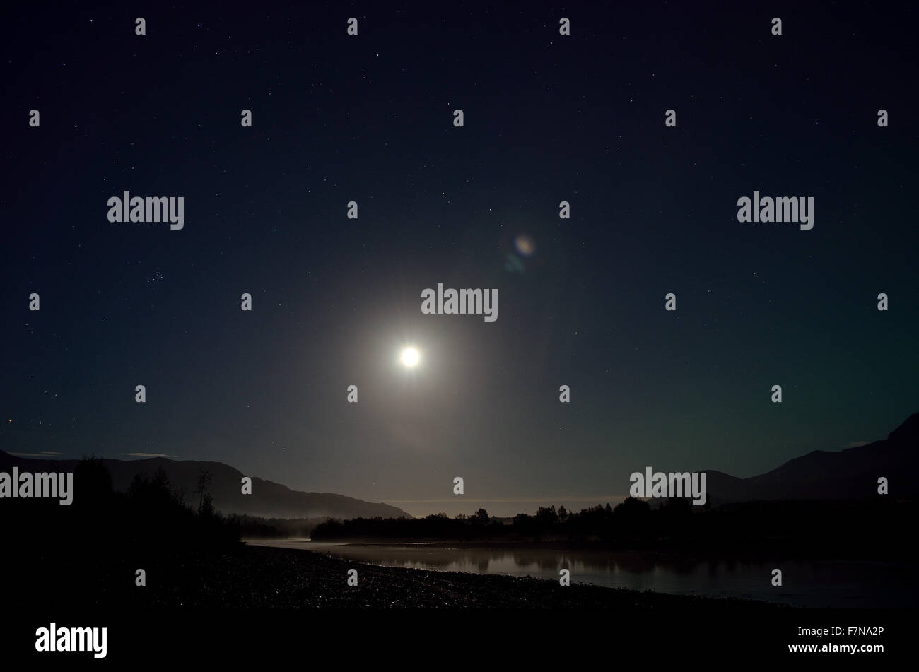 faded aurora borealis on full moon night as the moonlight reflected by ...