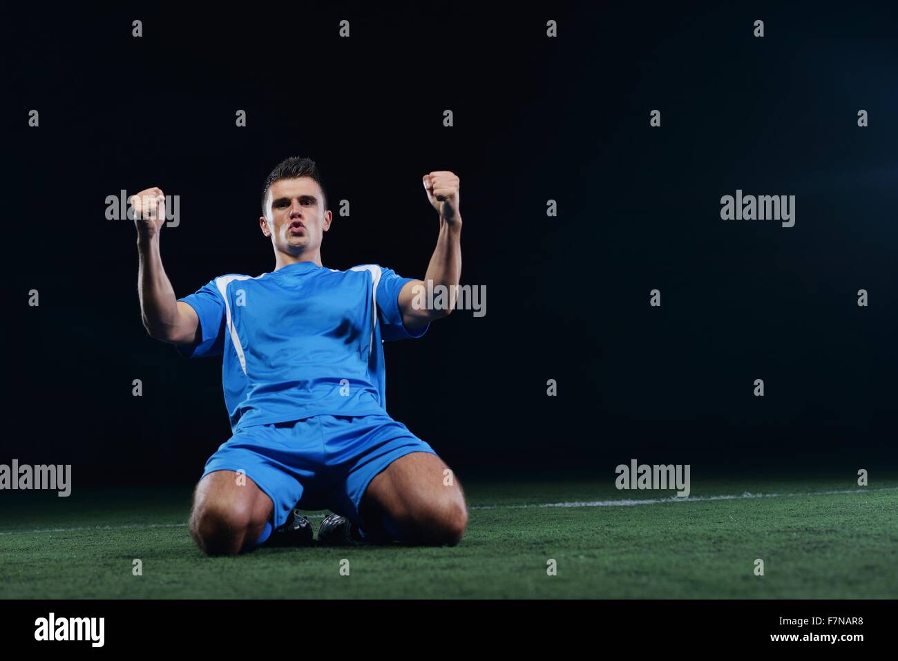 soccer player doing kick with ball on football stadium field isolated ...