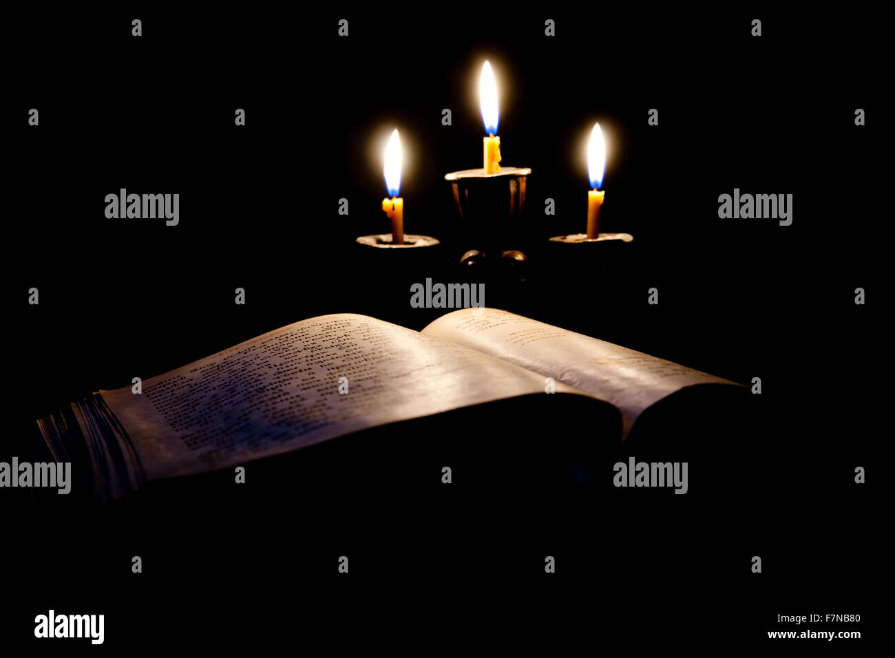 old Psalter and candles in candelabrum against black Stock Photo - Alamy
