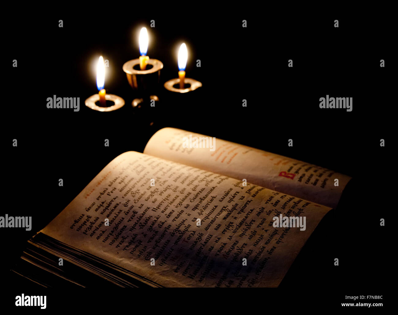 old Psalter and candles in candelabrum against black Stock Photo - Alamy
