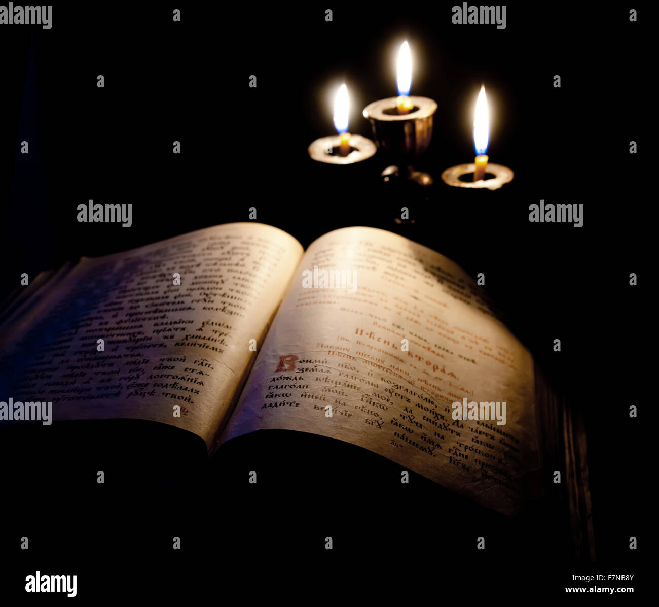 old Psalter and candles in candelabrum against black Stock Photo - Alamy