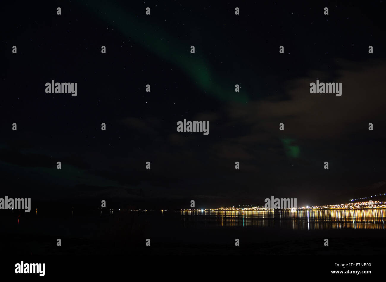 magnificent aurora borealis over arctic city lights, fjord and mountain ...