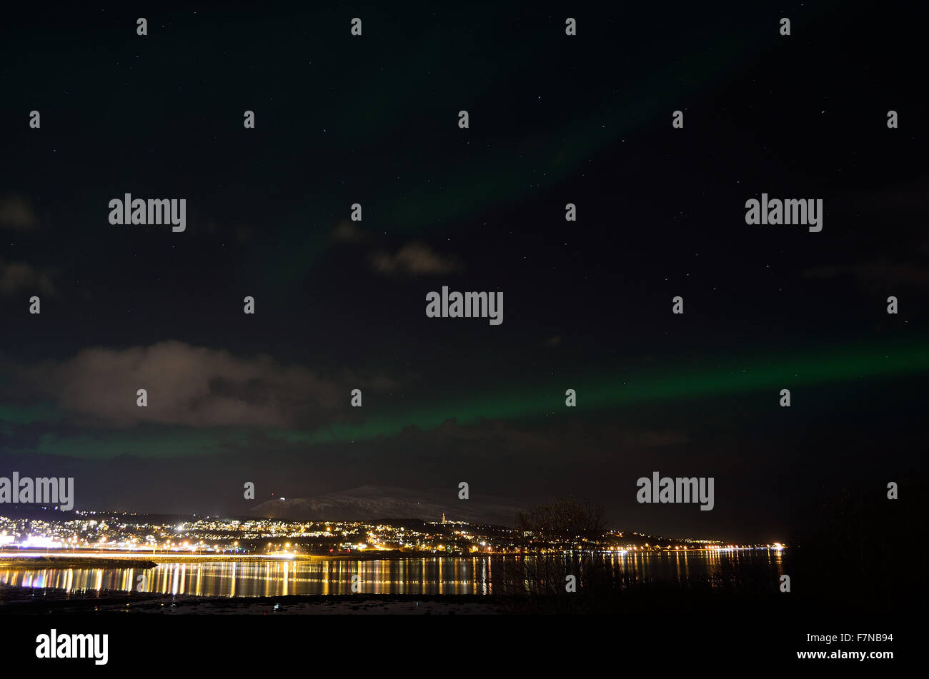 magnificent aurora borealis over arctic city lights, fjord and mountain ...