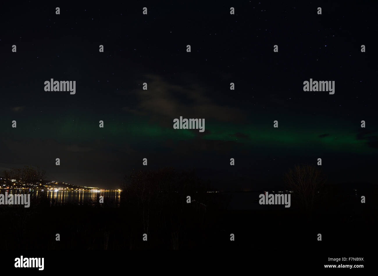 magnificent aurora borealis over arctic city lights, fjord and mountain ...