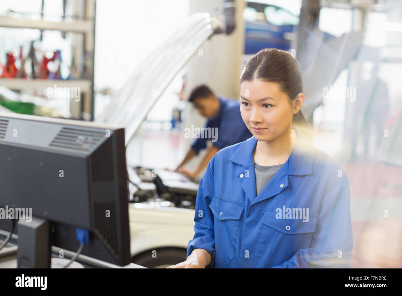 Female mechanic working at computer in auto repair shop Stock Photo - Alamy