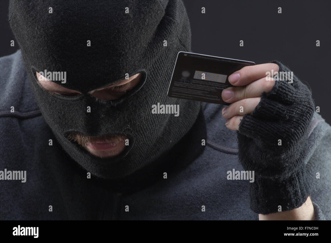 Hacker hold stolen credit card in hand Stock Photo - Alamy