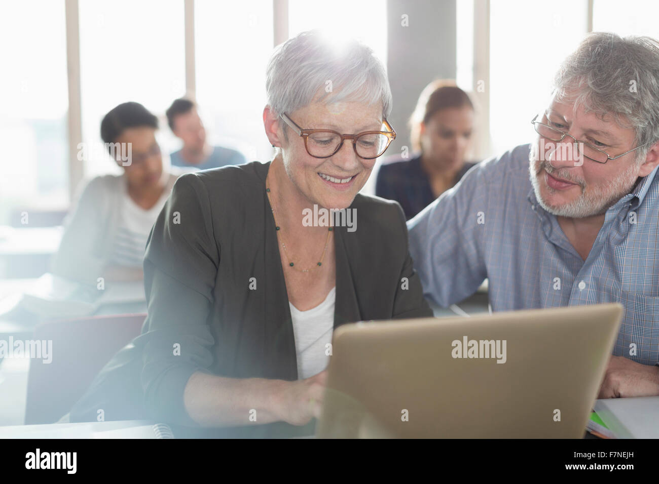 Students studying at laptop in adult education classroom Stock Photo ...