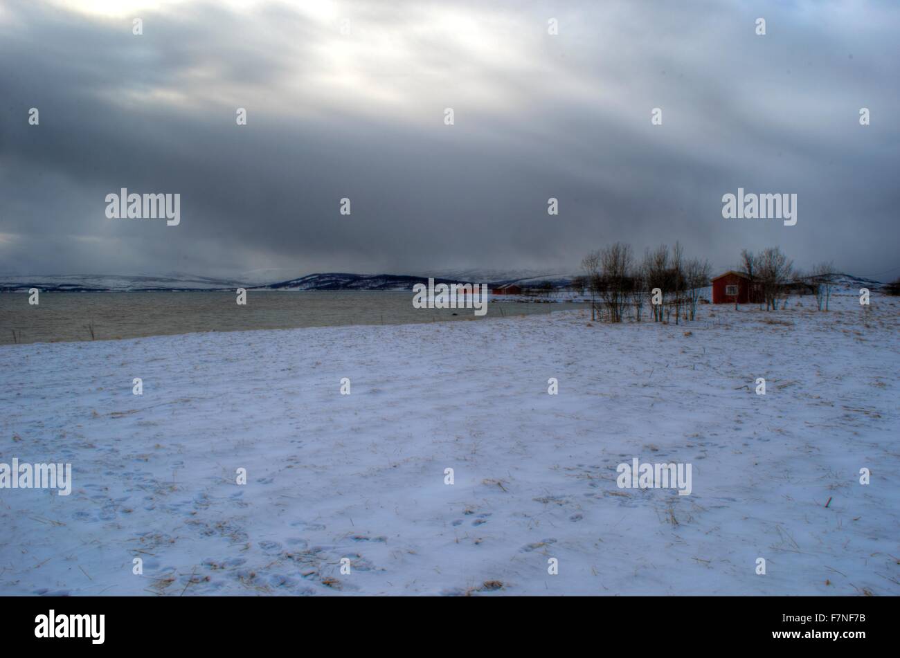 long deep snowy field with mountain and clouds in the distance with sea ...