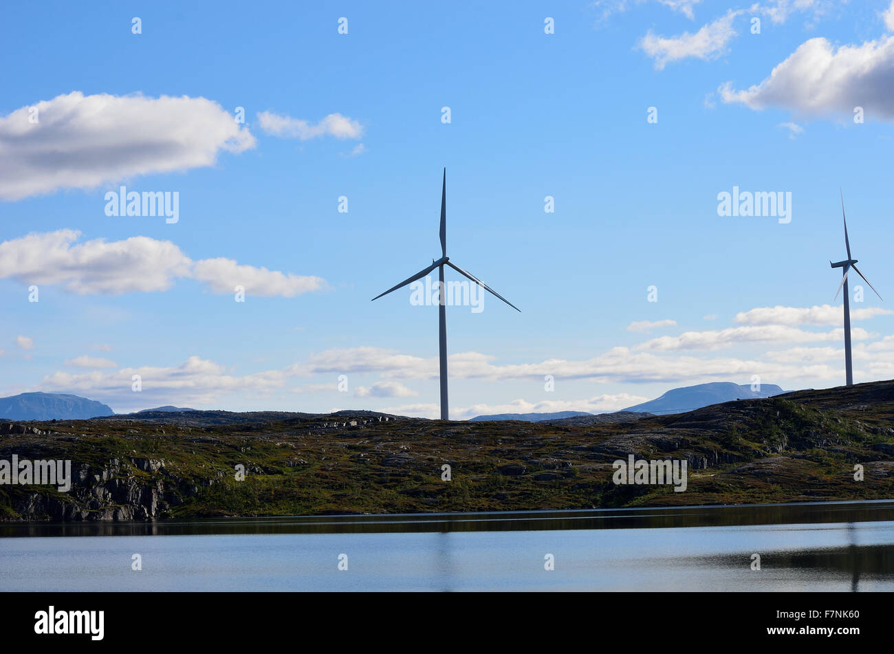 windmill on mountain top reflecting in the lake water on a sunny blue ...