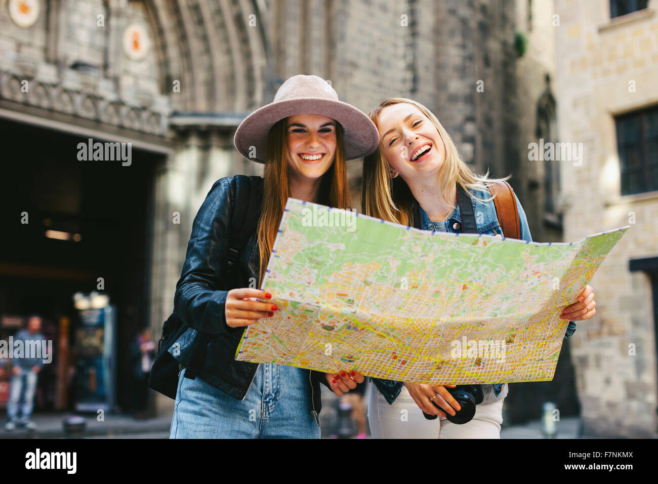 Two happy young women reading map hi-res stock photography and images ...