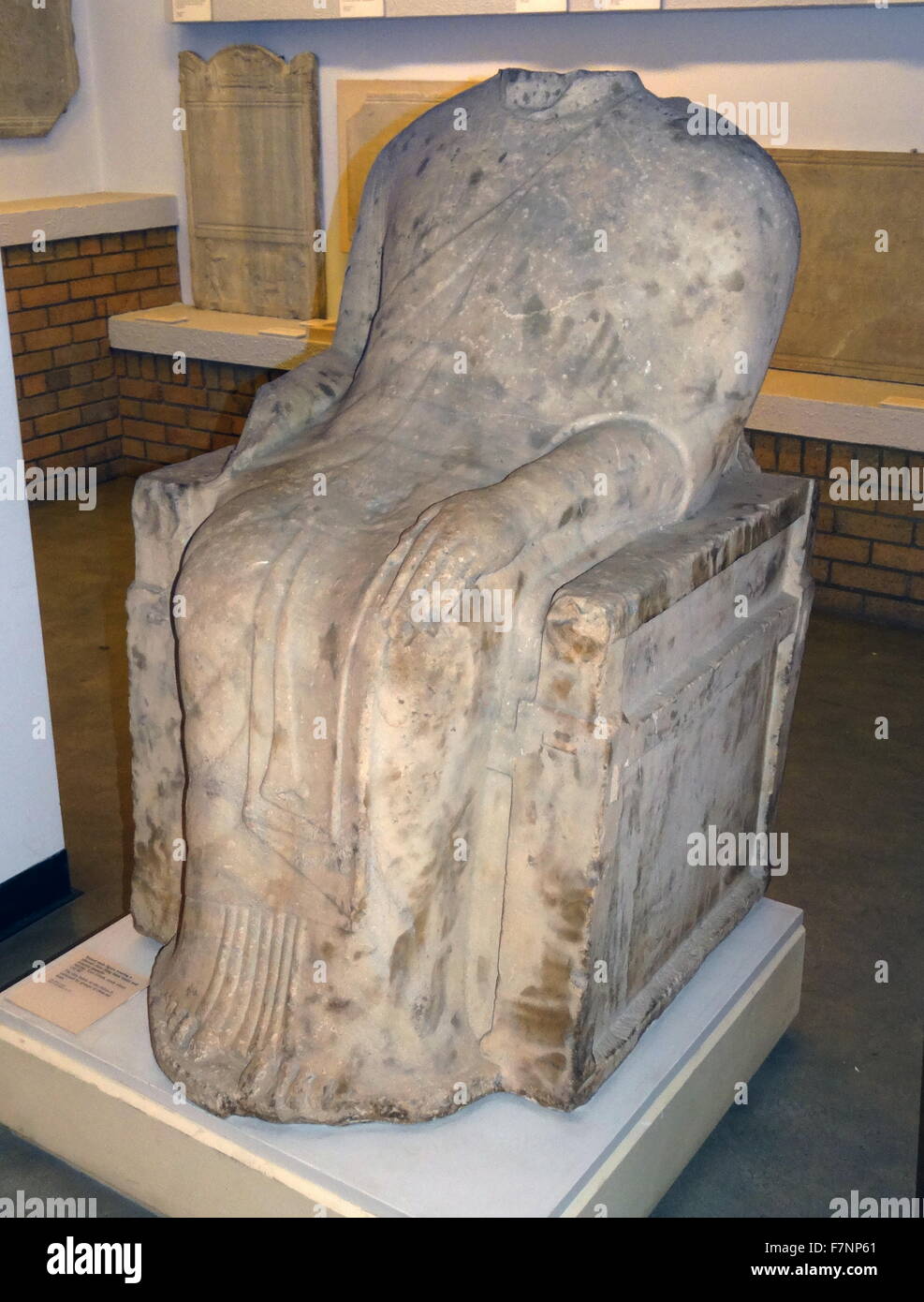 Seated male figure wearing a decorated sleeved chiton and himation ...
