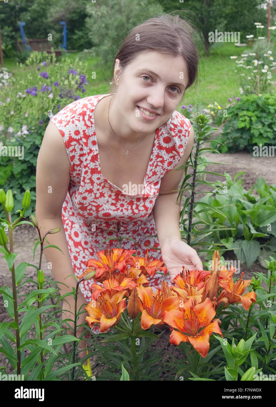 Beautiful young woman in the yard gardening Stock Photo - Alamy