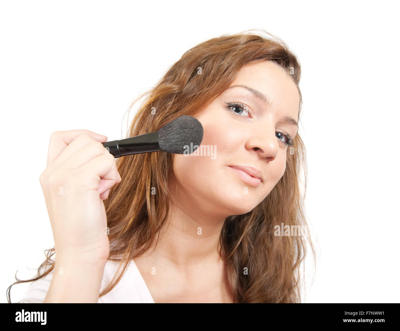 Girl putting facial powder on her face with a brush, white background ...
