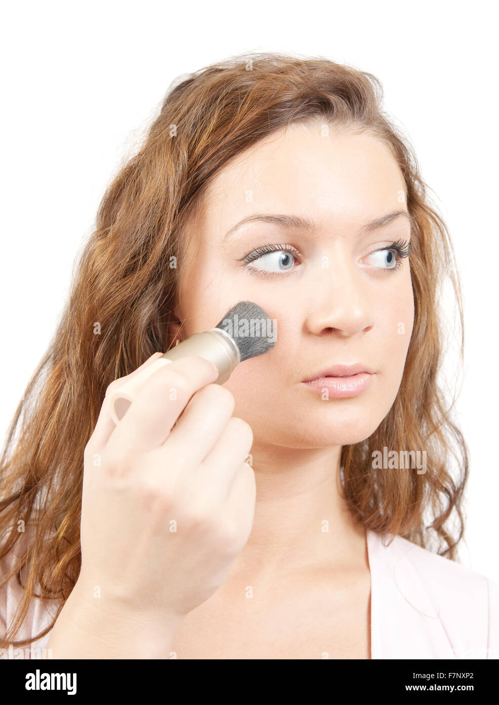 Girl putting facial powder on her face with a brush, white background ...