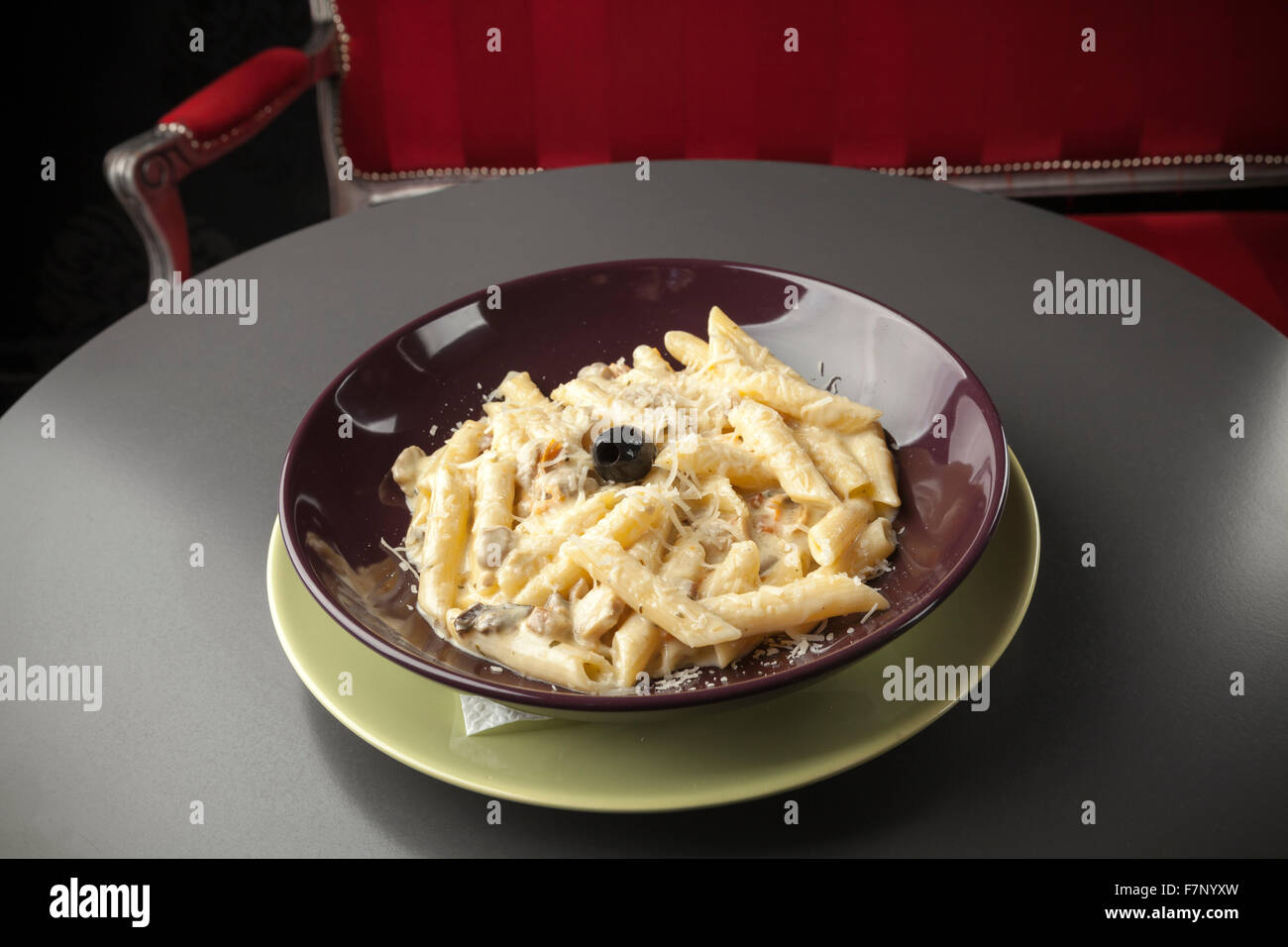 Pasta on black table with black olive Stock Photo - Alamy