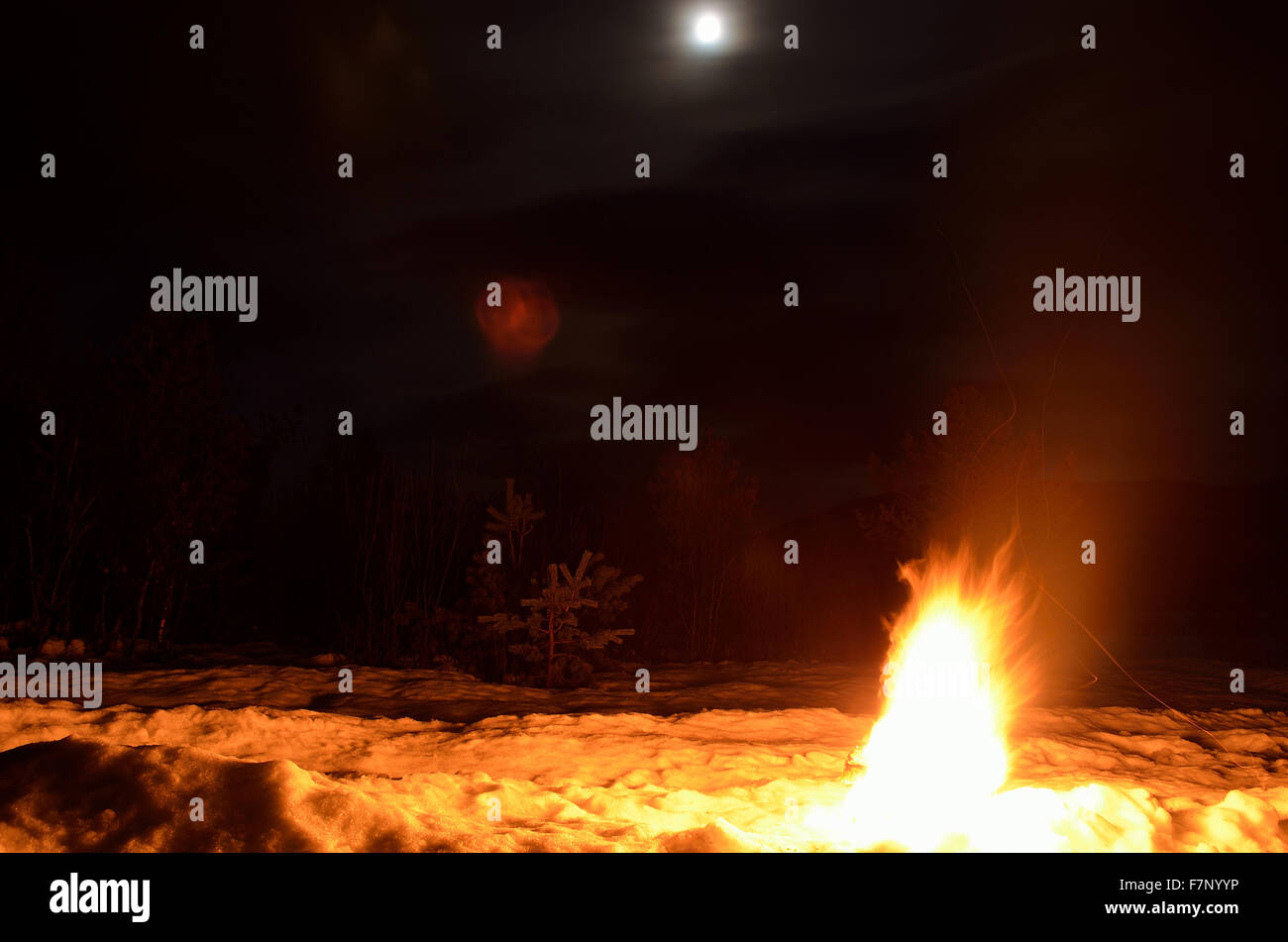 birch log fire on winter snow on a dark full moon night Stock Photo - Alamy