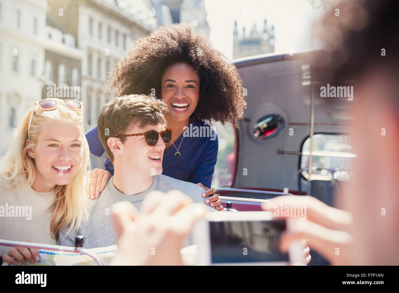 Enthusiastic friends being photographed on double-decker bus Stock ...