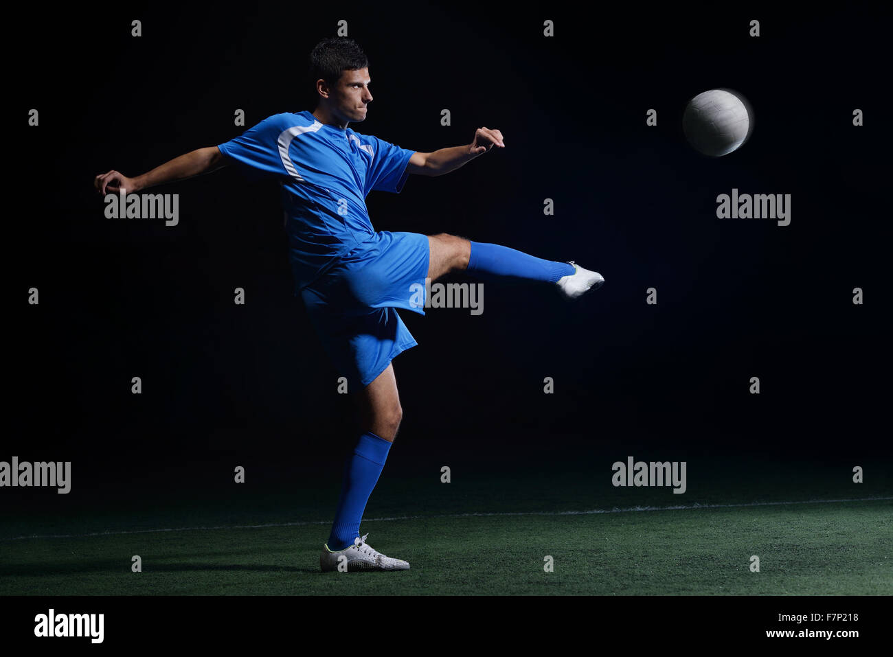soccer player doing kick with ball on football stadium field isolated on black background Stock ...