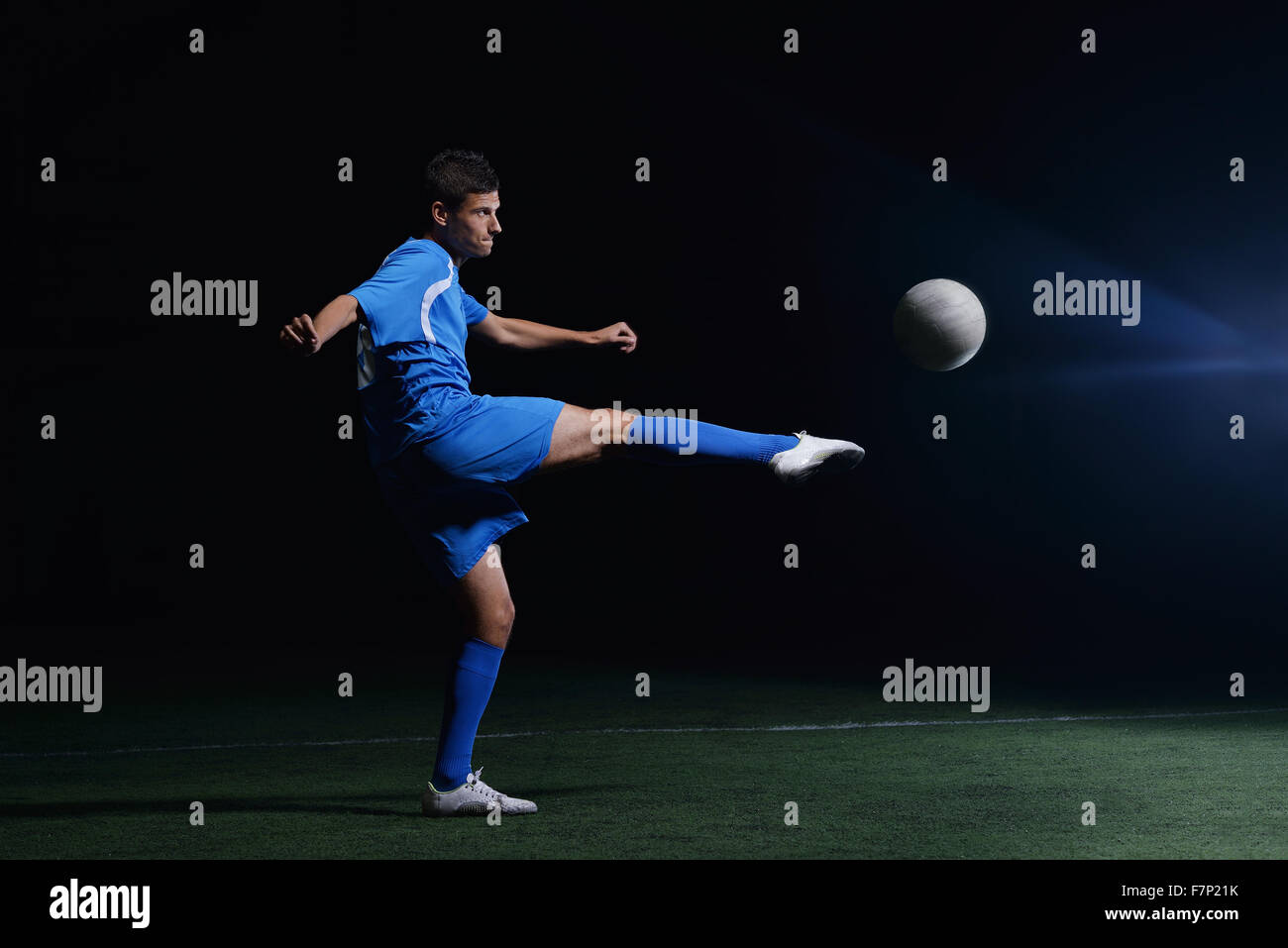 soccer player doing kick with ball on football stadium field isolated ...