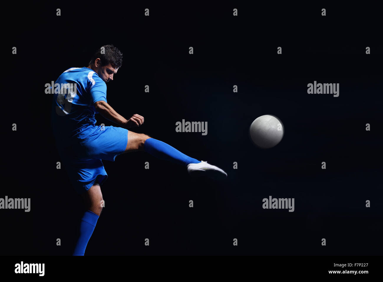 soccer player doing kick with ball on football stadium field isolated ...
