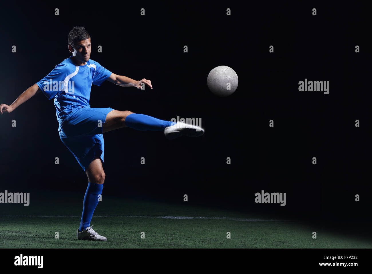 soccer player doing kick with ball on football stadium field isolated on black background Stock ...
