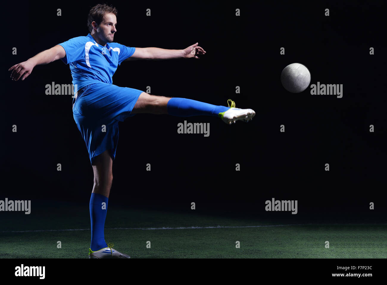 soccer player doing kick with ball on football stadium field isolated on black background Stock ...
