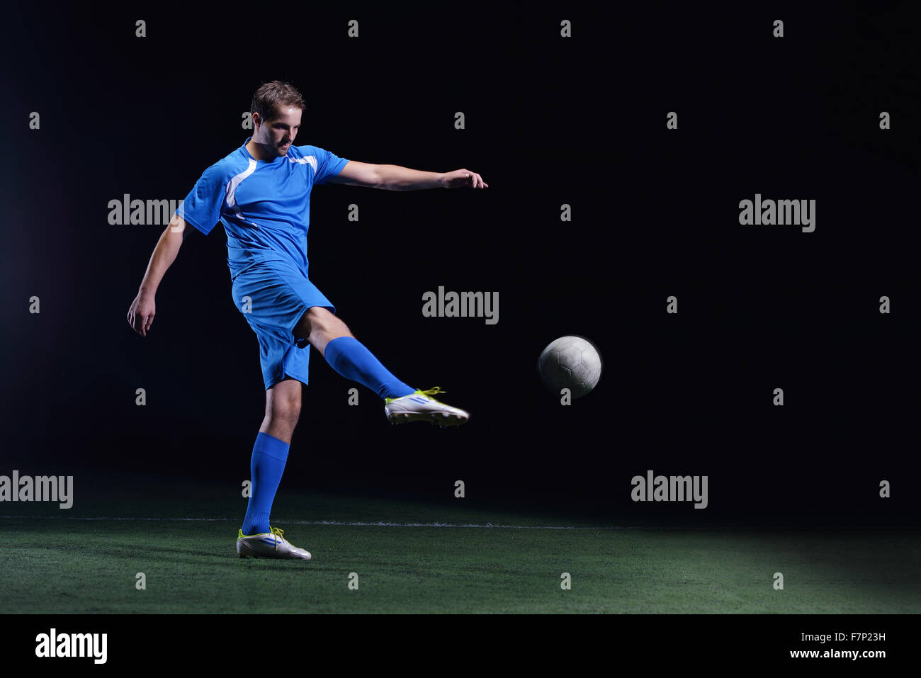 soccer player doing kick with ball on football stadium field isolated ...