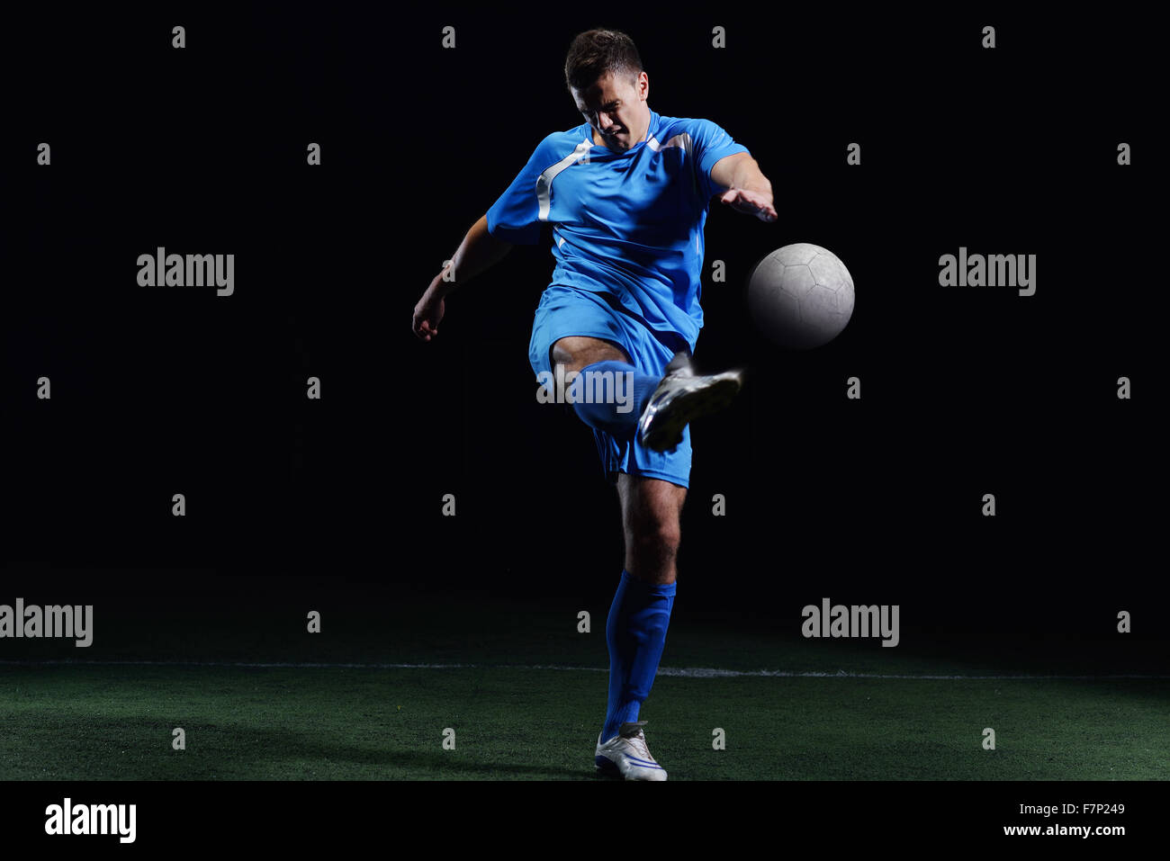 soccer player doing kick with ball on football stadium field isolated ...