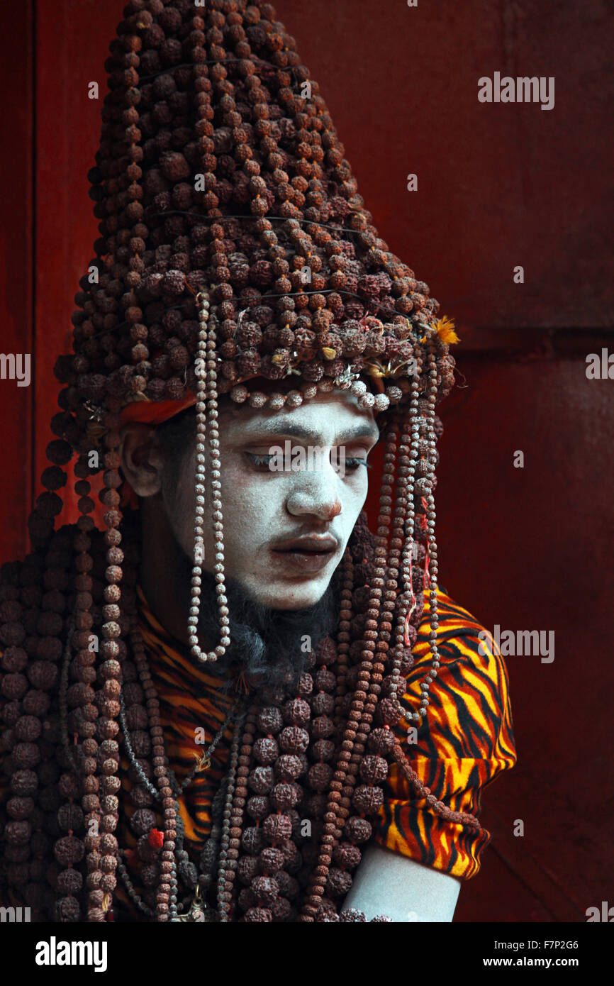 Sadhu with painted face and heavy beads on head and neck. Kumbh Mela ...