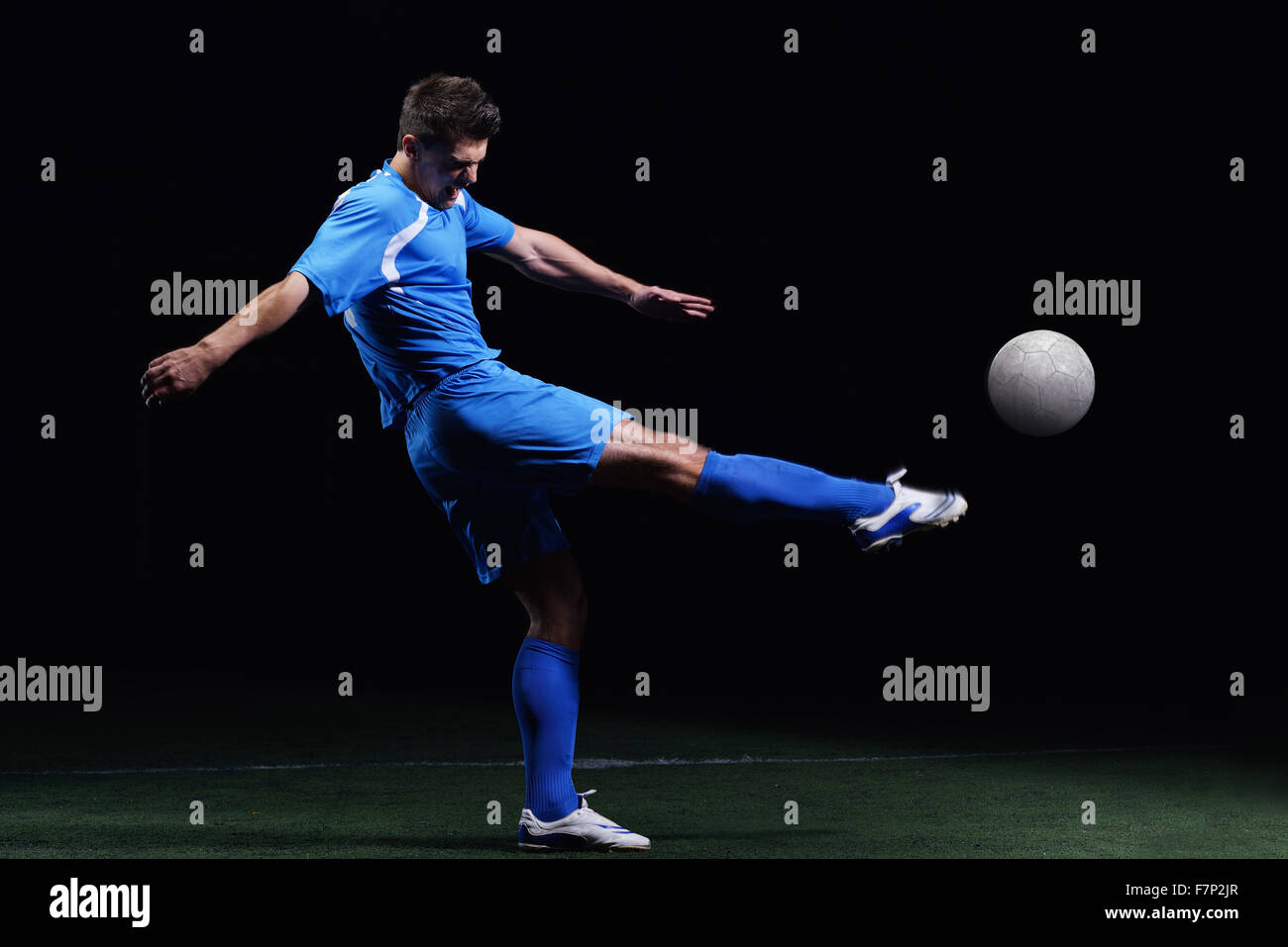 soccer player doing kick with ball on football stadium field isolated ...