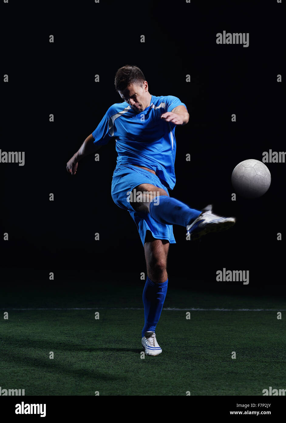 soccer player doing kick with ball on football stadium field isolated on black background Stock ...