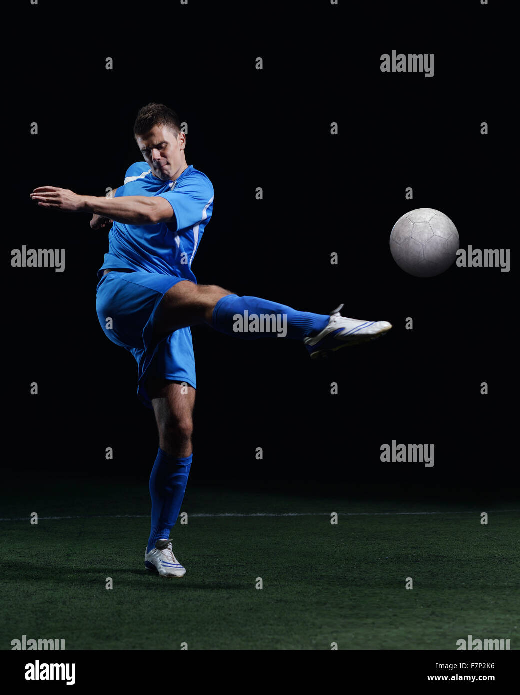 soccer player doing kick with ball on football stadium field isolated ...