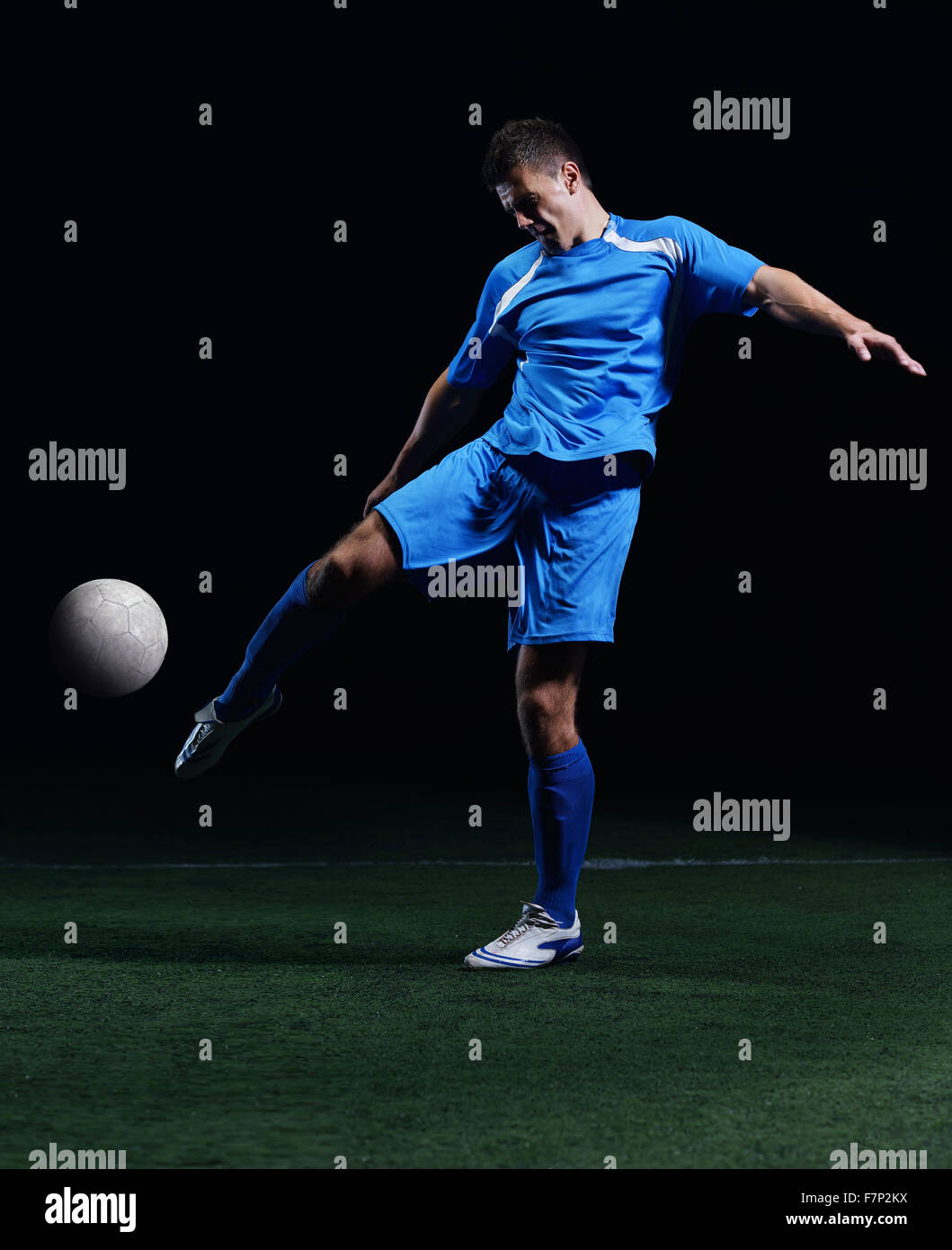 soccer player doing kick with ball on football stadium field isolated ...