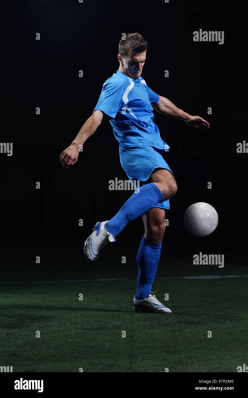 soccer player doing kick with ball on football stadium field isolated ...