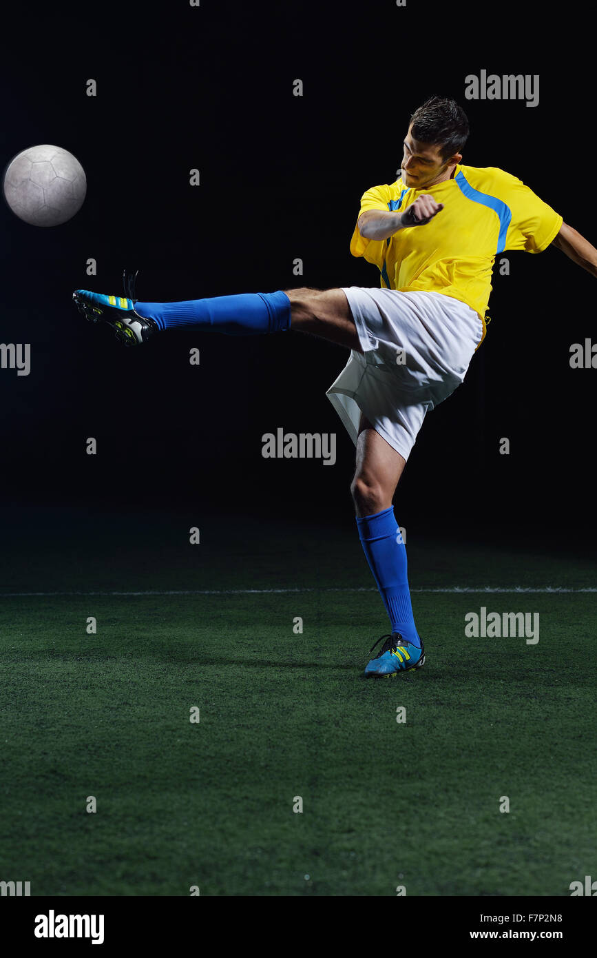 soccer player doing kick with ball on football stadium field isolated on black background Stock ...