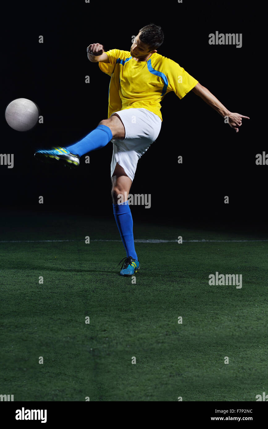 soccer player doing kick with ball on football stadium field isolated ...