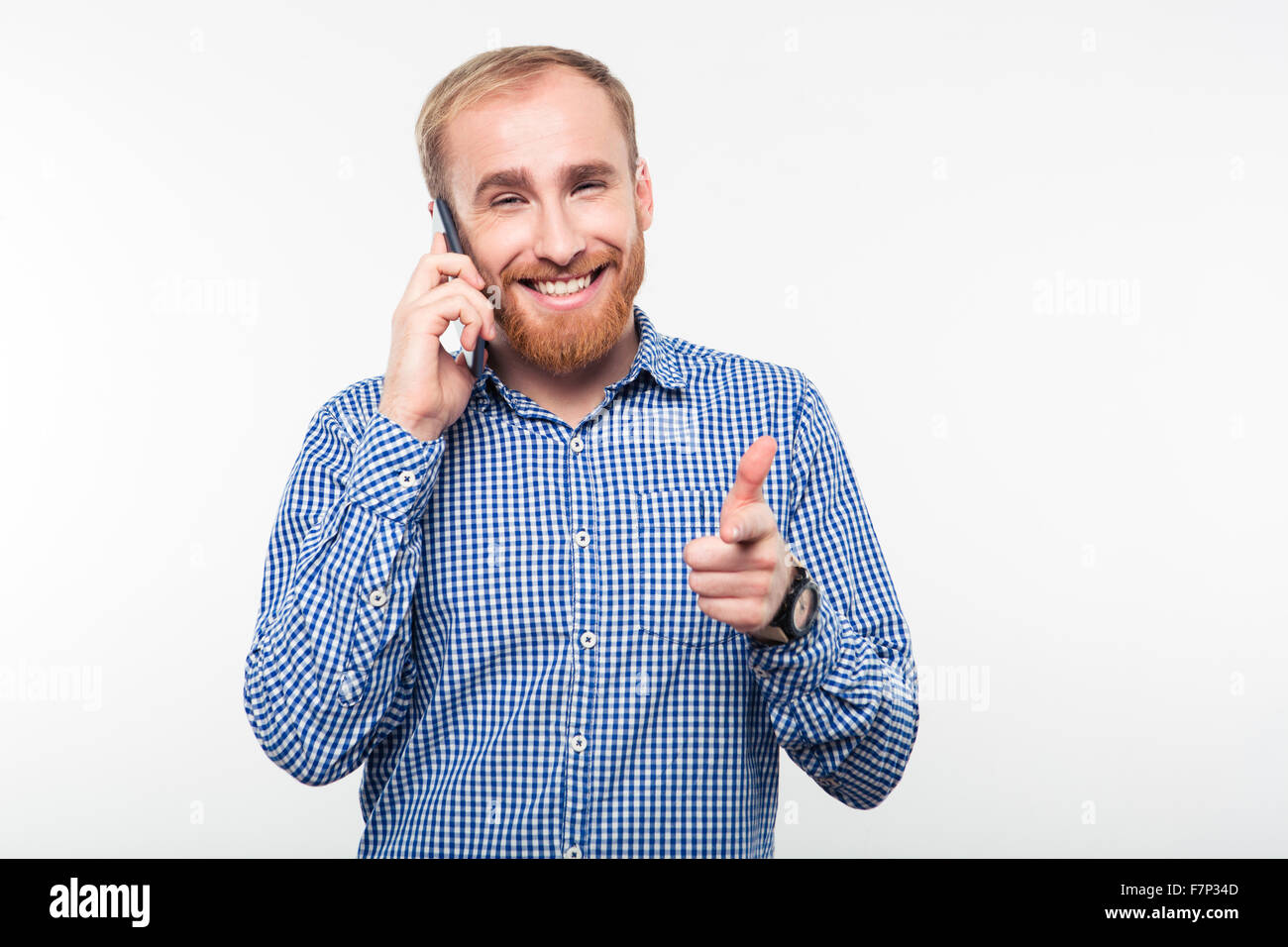 Portrait of a smiling man talking on the phone and showing gun gesture ...