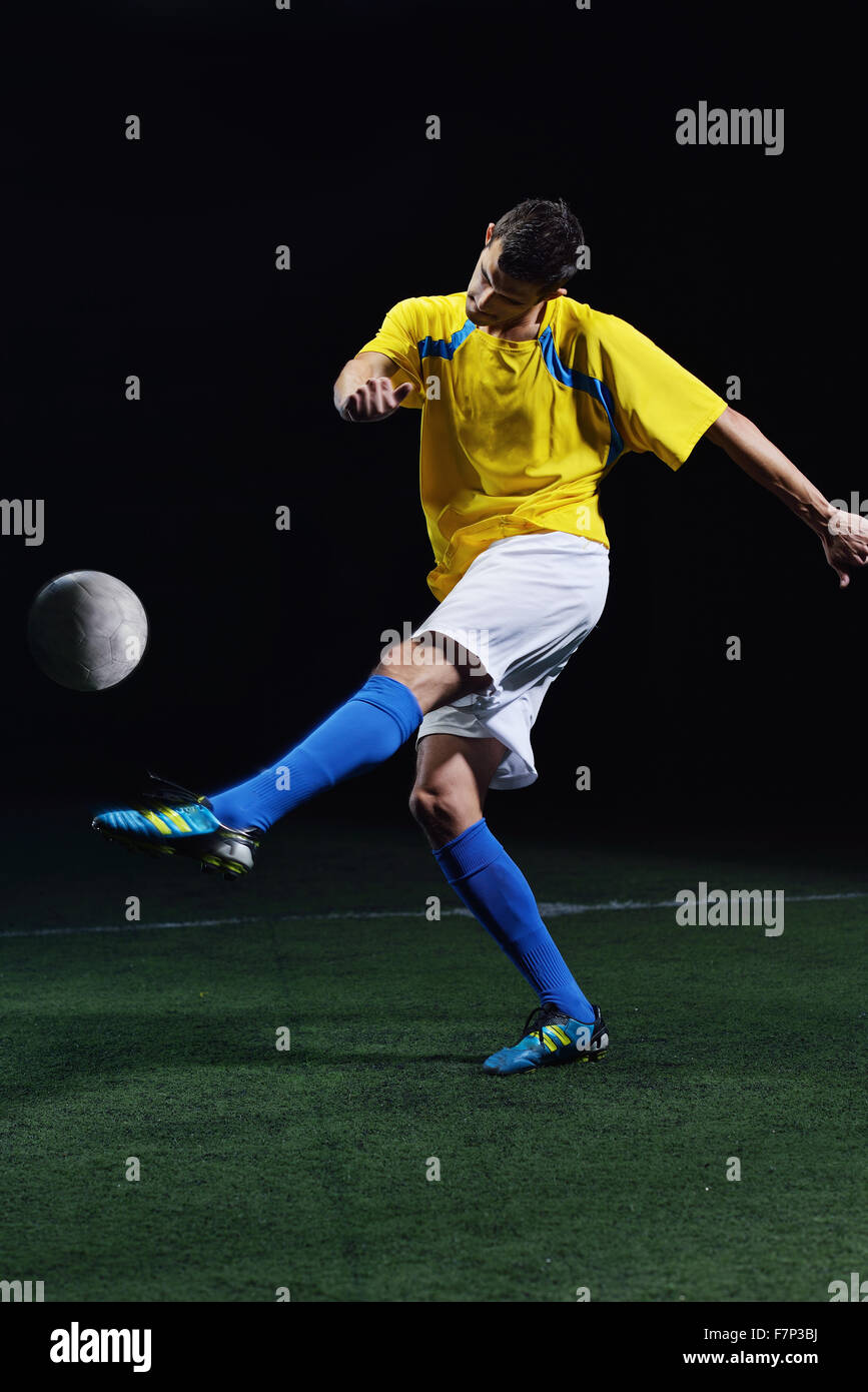soccer player doing kick with ball on football stadium field isolated ...