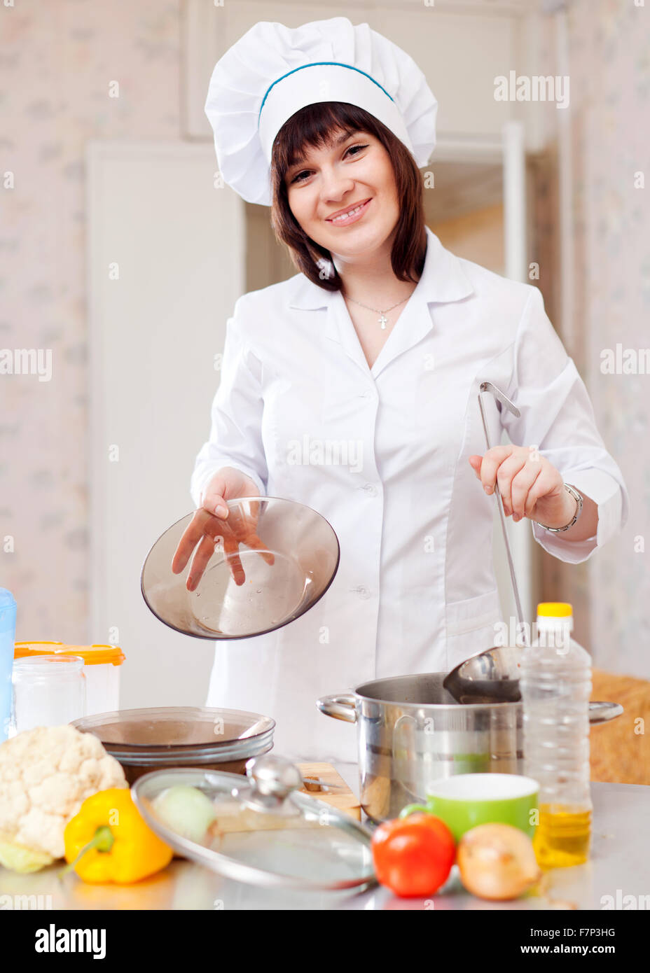 cook woman with ladle pours soup from pan Stock Photo - Alamy