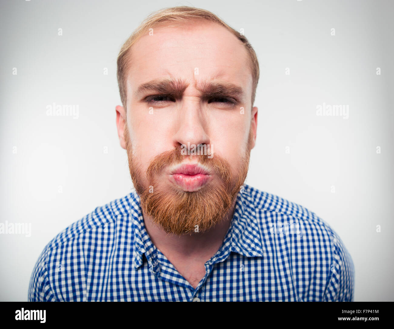 Portrait of a funny young man inflate his cheeks isolated on a white ...