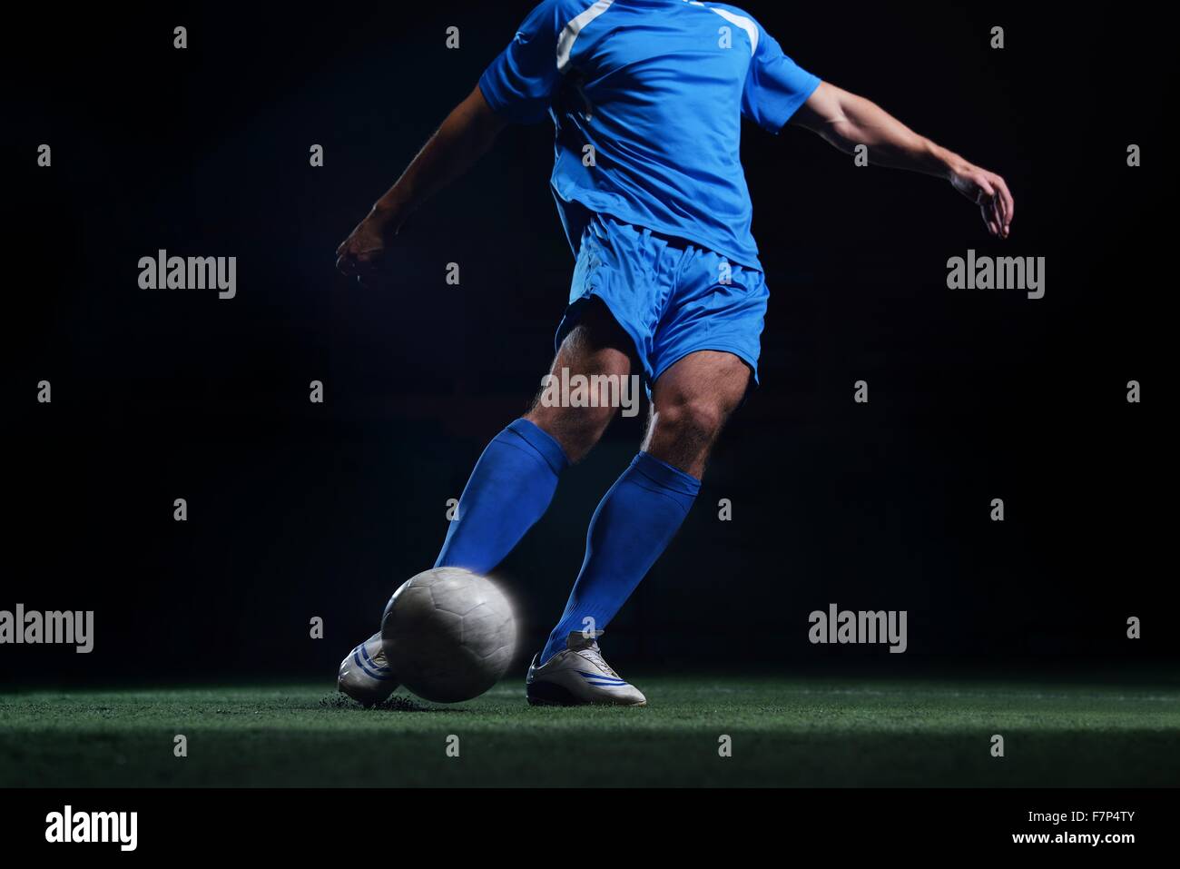 soccer player doing kick with ball on football stadium field isolated ...