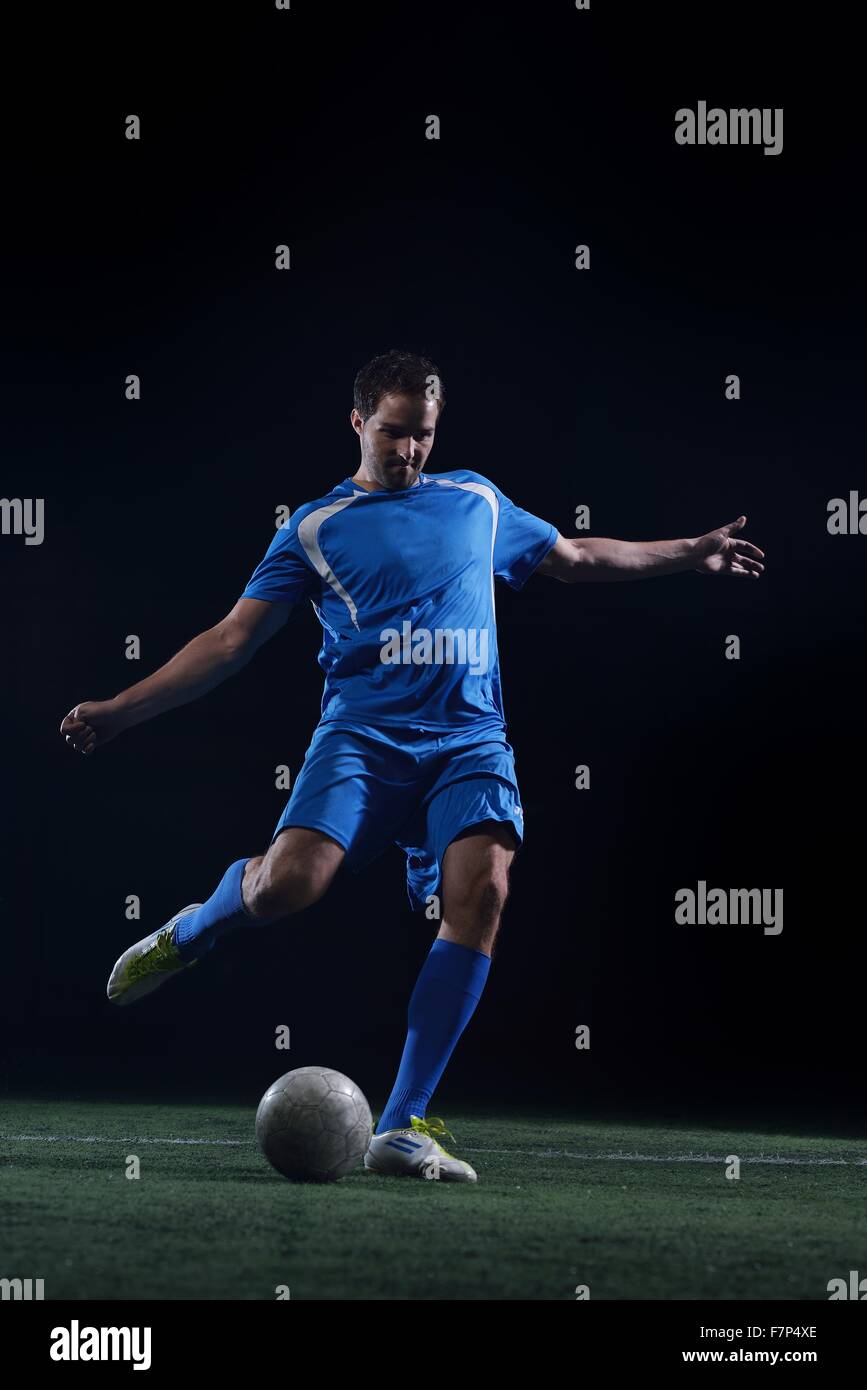 soccer player doing kick with ball on football stadium field isolated ...