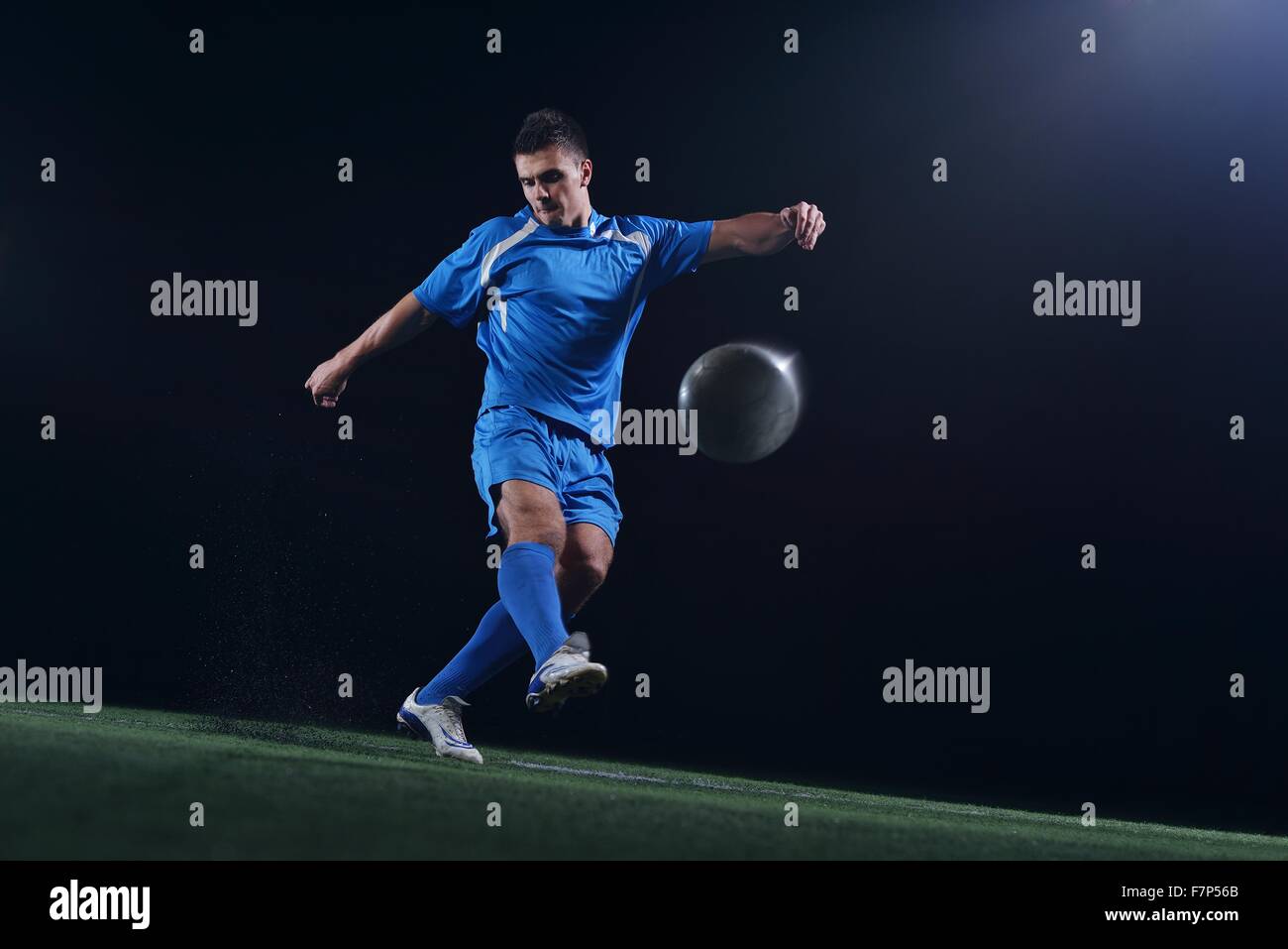 soccer player doing kick with ball on football stadium field isolated on black background Stock ...