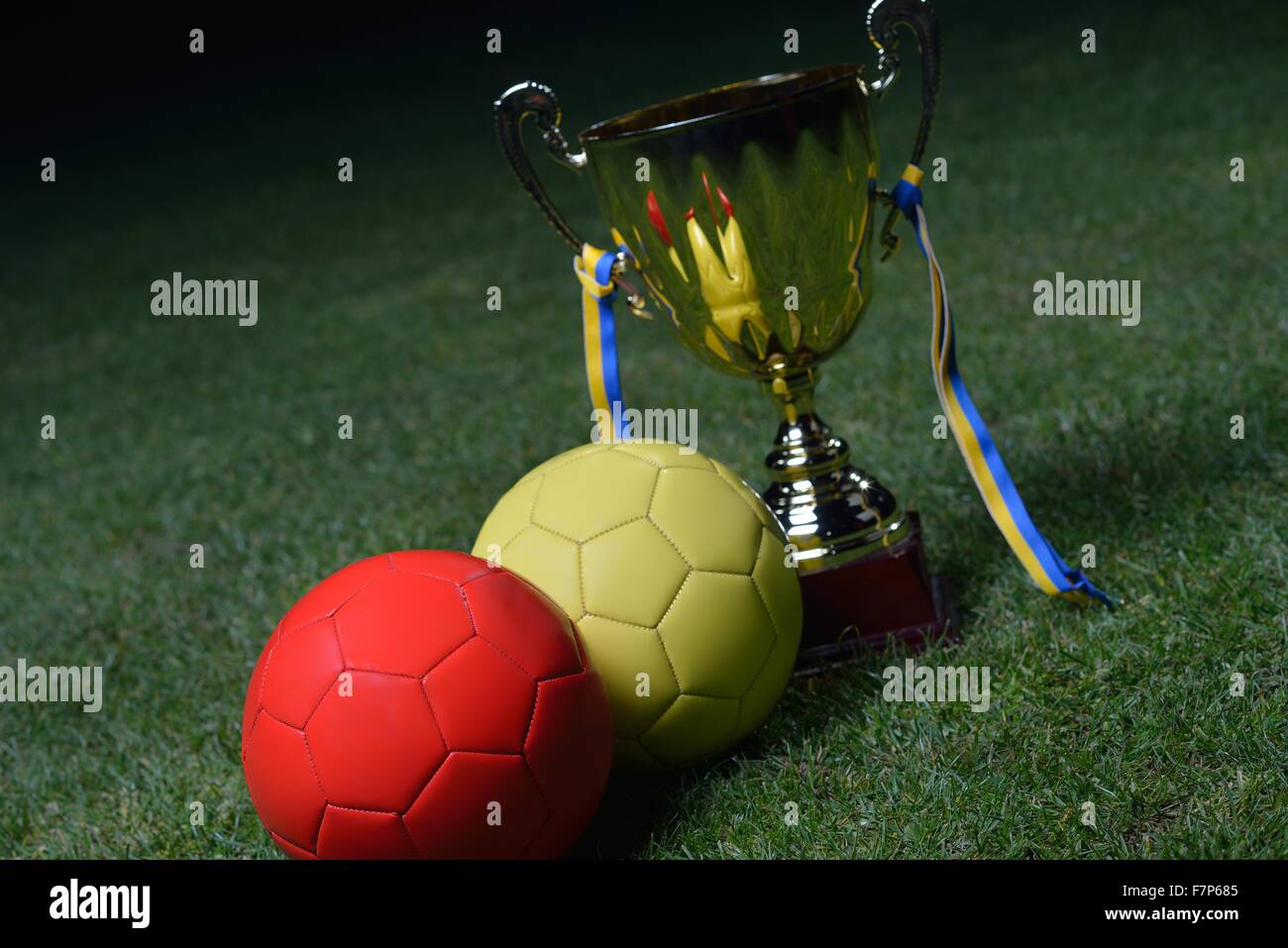 Golden soccer cup and ball on grass field Stock Photo - Alamy