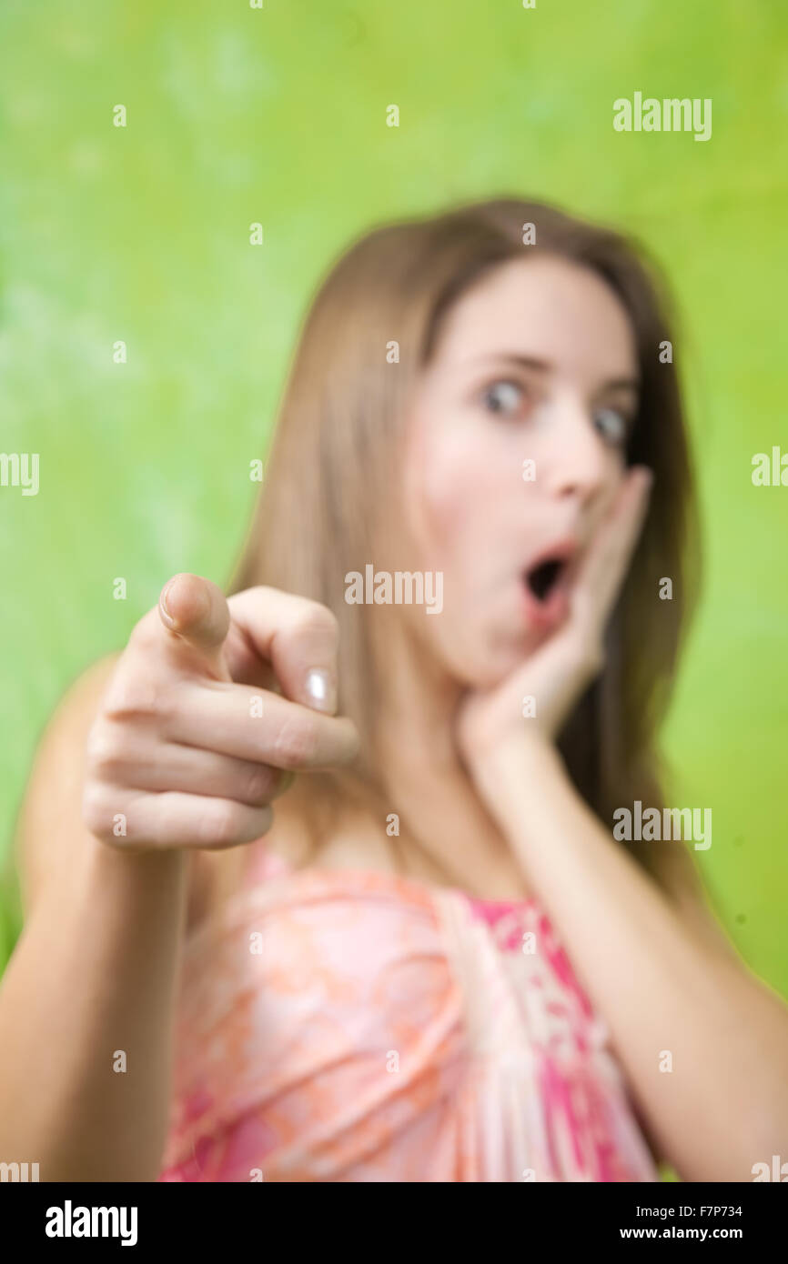 Portrait of a happy and surprised young woman, focus on finger Stock ...