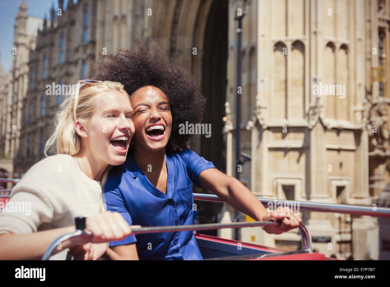 Enthusiastic friends laughing on double-decker bus in London Stock ...