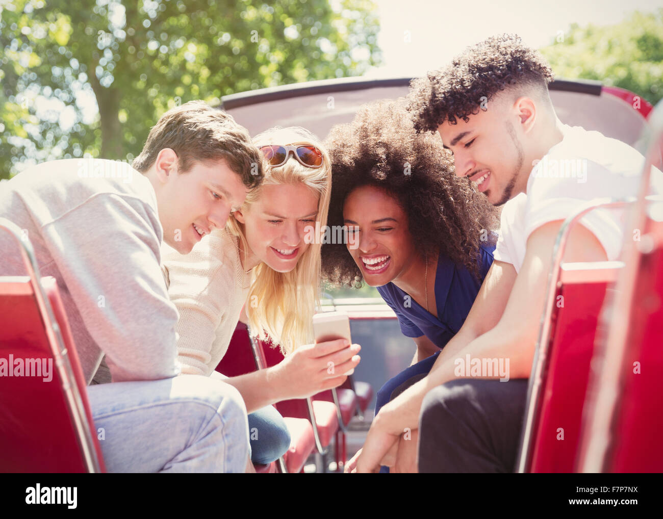 Friends texting with cell phone on double-decker bus Stock Photo - Alamy