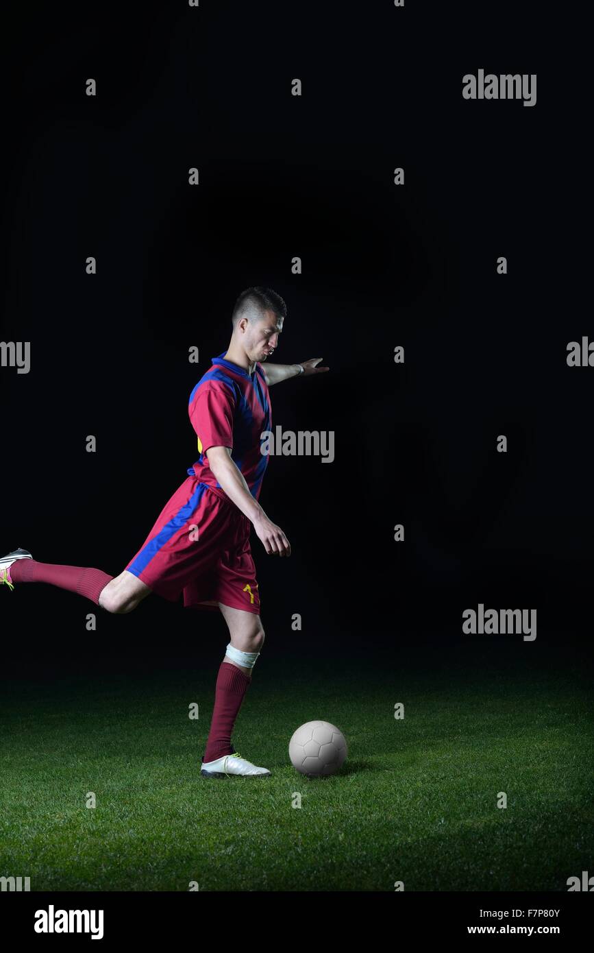soccer player doing kick with ball on football stadium field isolated ...