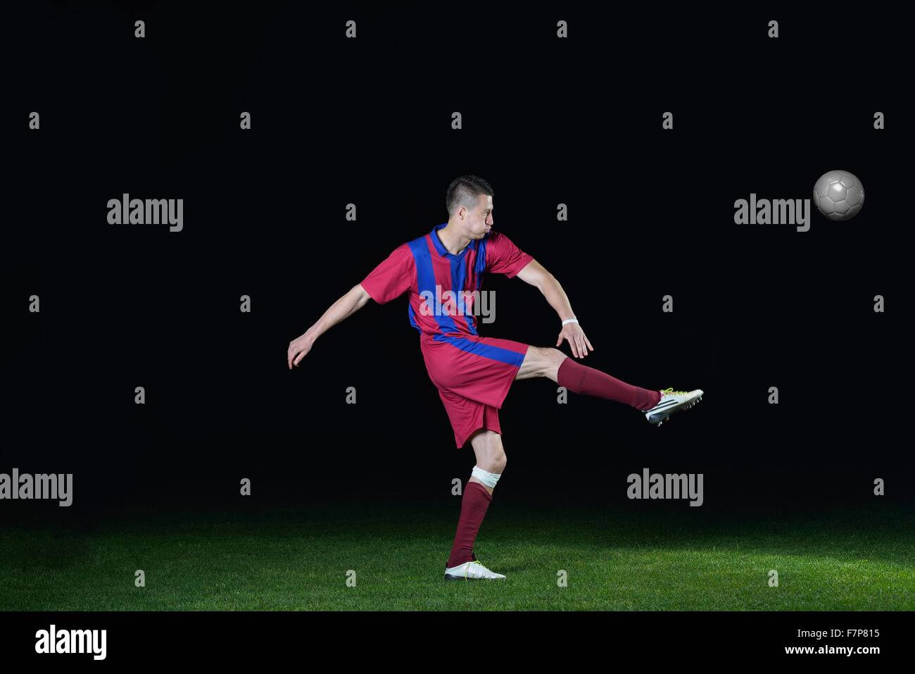 soccer player doing kick with ball on football stadium field isolated ...
